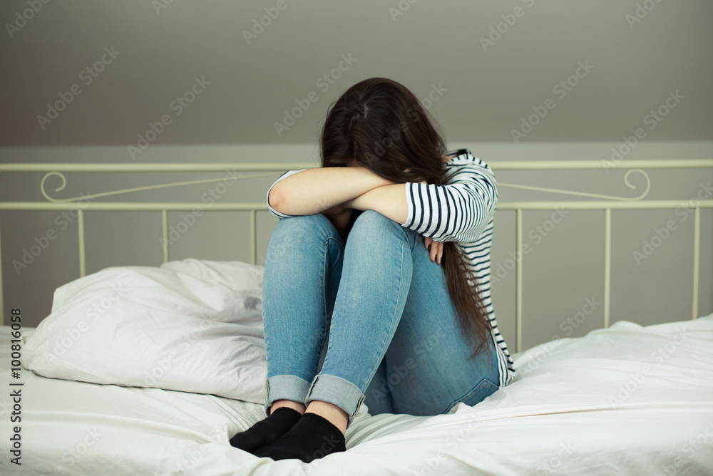 sad girl sitting on bed Stock Photo | Adobe Stock