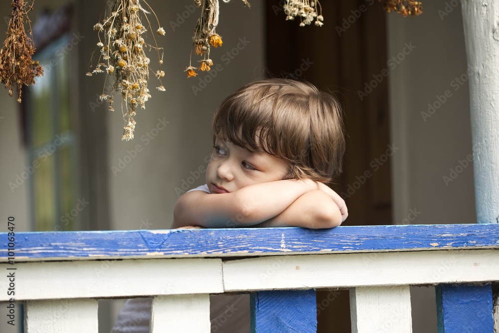 sad little boy on the porch of rural house Stock Photo | Adobe Stock