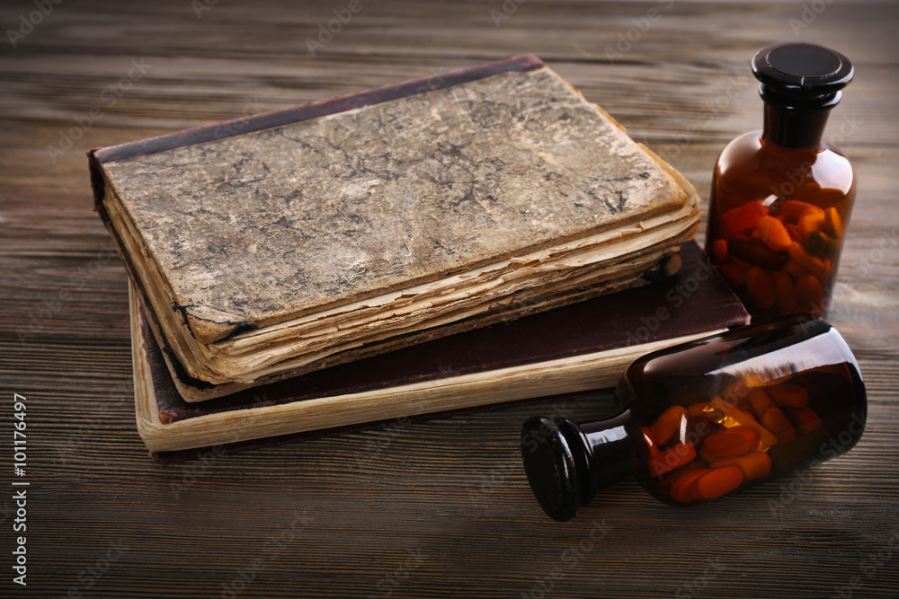 Books and pills on wooden table closeup Stock Photo | Adobe Stock