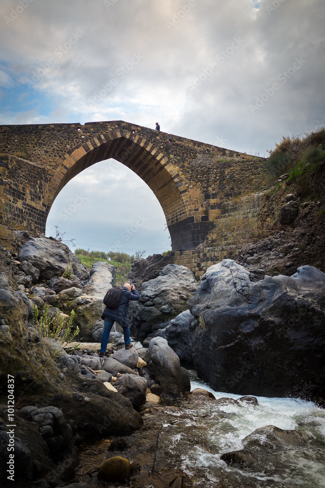 Photographer taking a photo to a man walking on the "Bridge of Saracens ...