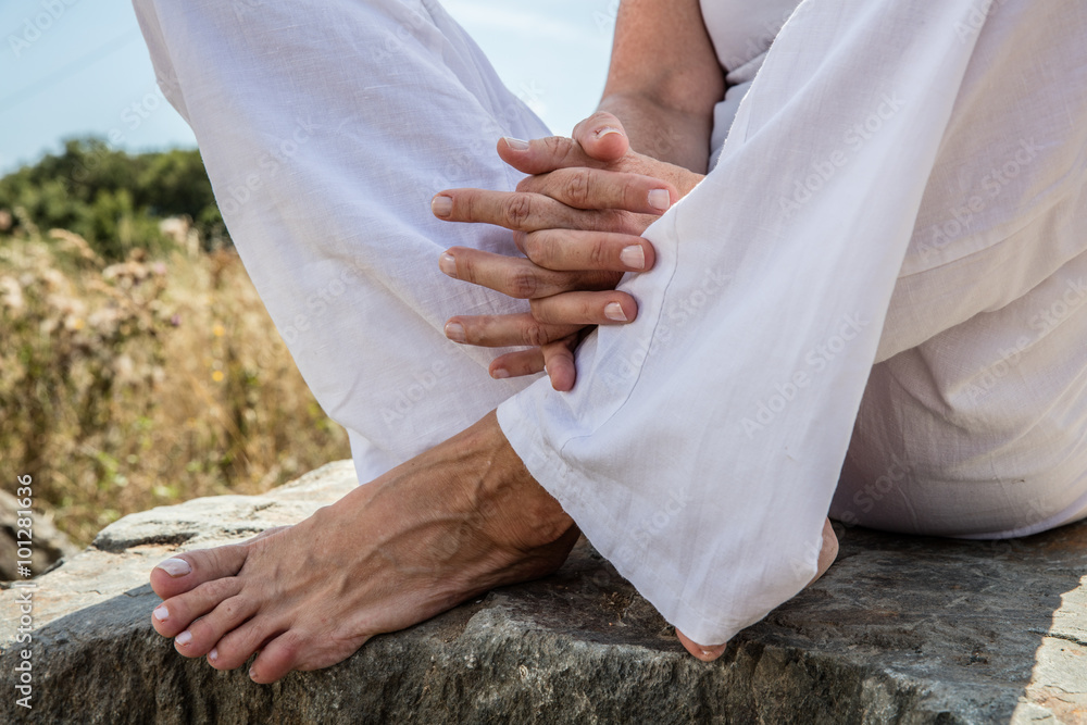 spirituality outdoors - closeup of praying hands and bare feet of a ...