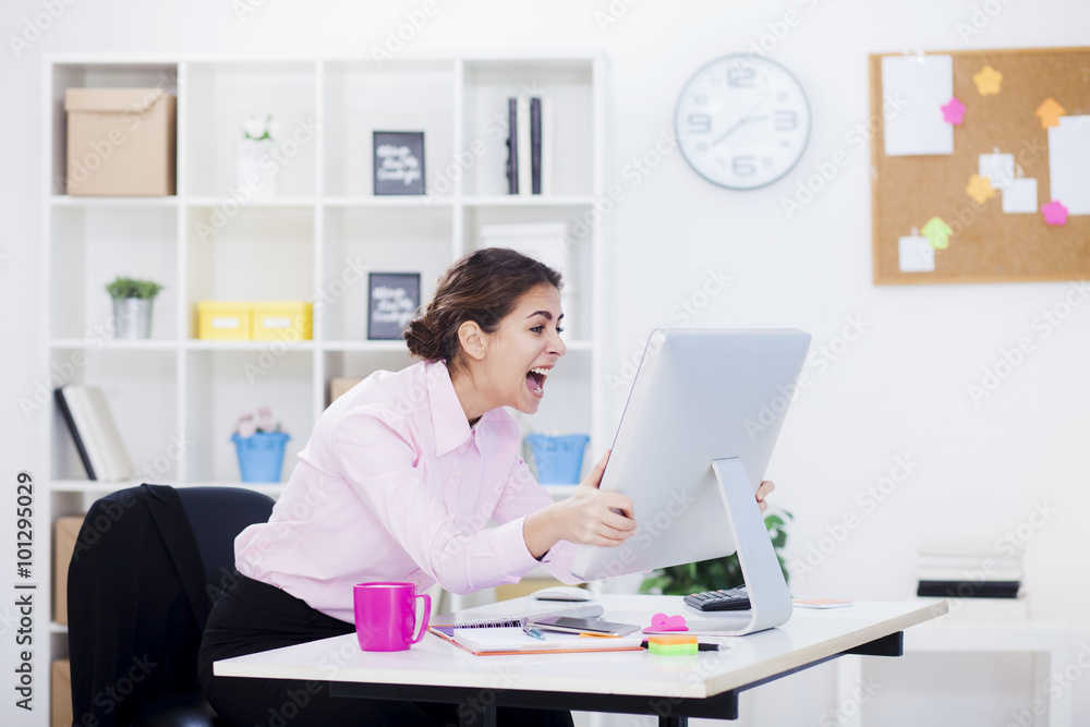 Businesswoman working at her desk,screaming in front on computer ...