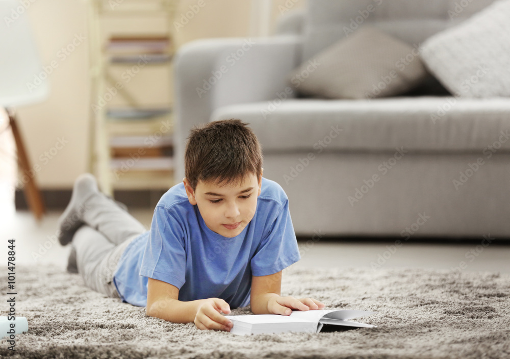 Boy reading book on a floor at home Stock Photo | Adobe Stock