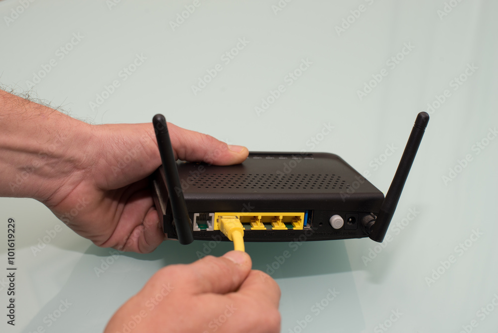 Conectando un cable de red a uno de los puertos de un router Stock ...