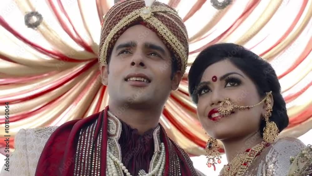 Shot of Indian bride and groom in traditional wedding dress under a ...