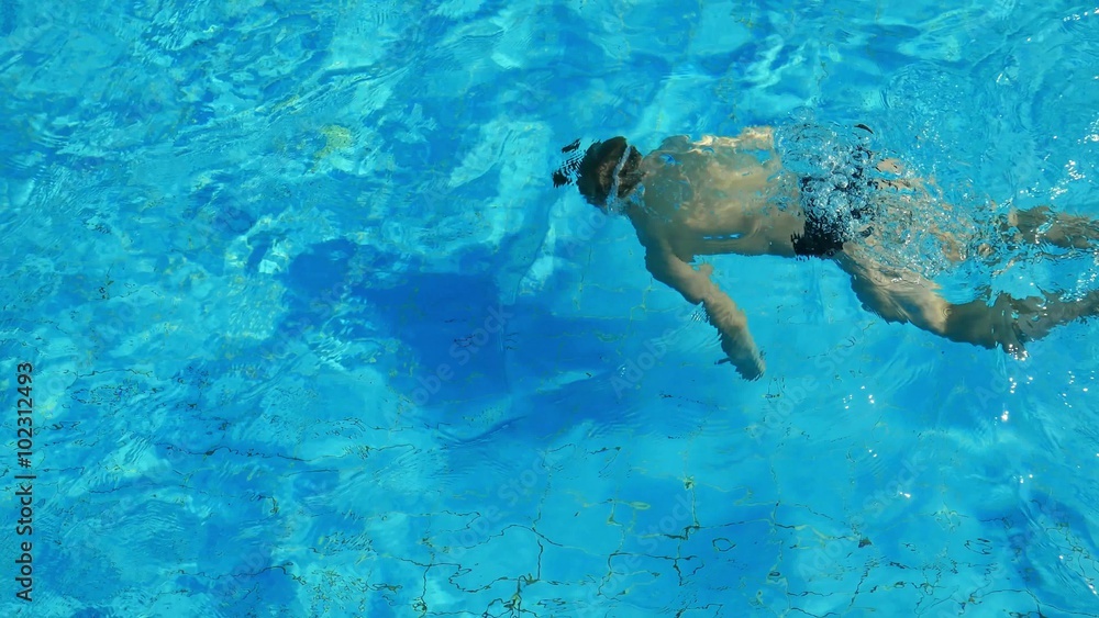 Caucasian child boy teen swimming, dives underwater in outdoor swimming ...