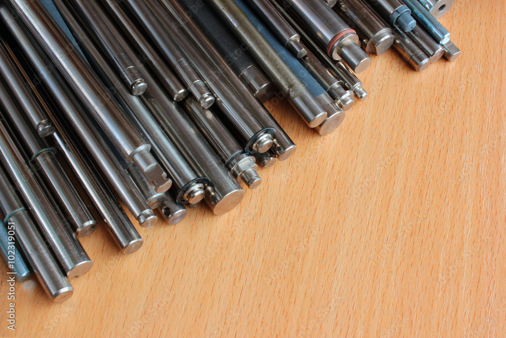 Shiny metal round bars and rods on wooden background Stock Photo ...