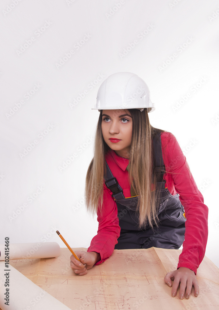 Female civil engineer standing next to the table, she bent over ...