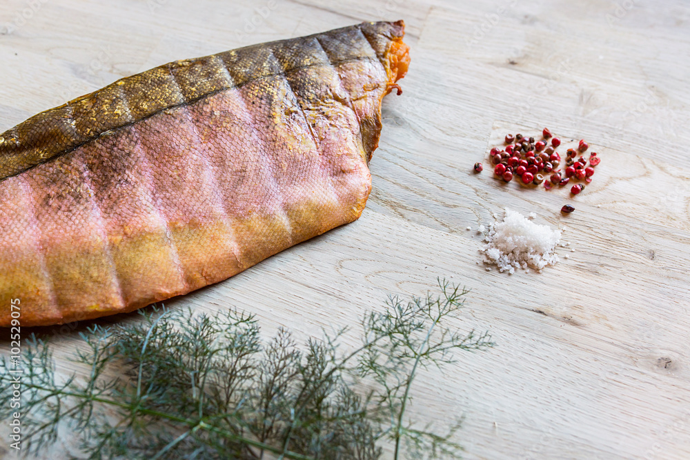 smoked haddock fish fillet on a natural oak tree table with a branch of ...