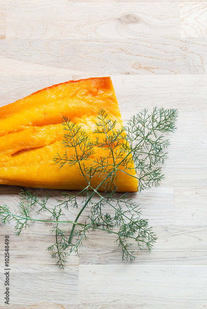 beautiful yellow smoked haddock fish fillet on a natural oak tree table ...