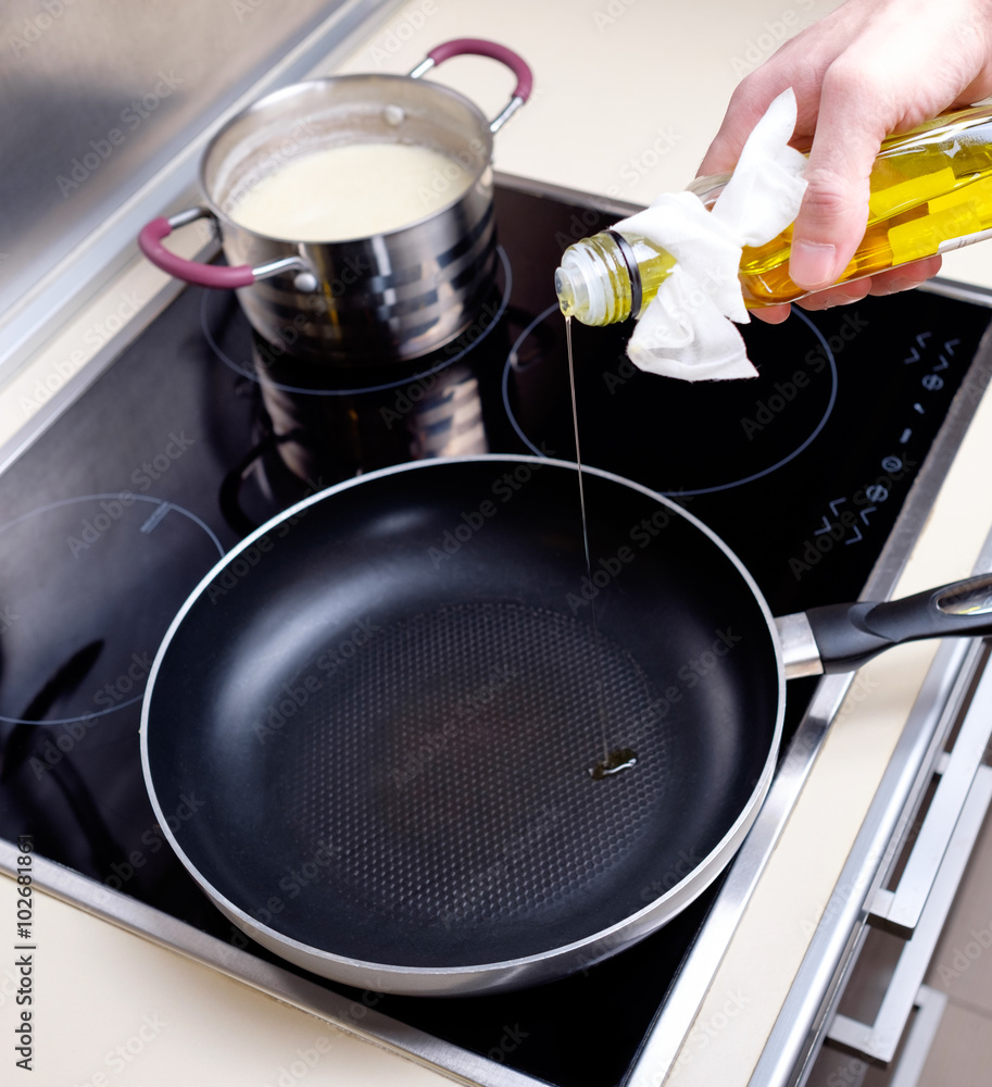 Dripping pan, olive oil and black induction cooker Stock Photo | Adobe ...