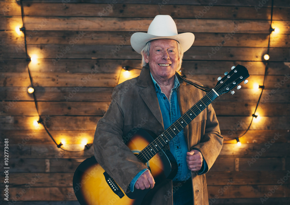 Smiling country and western musician standing with guitar. Stock-Foto ...