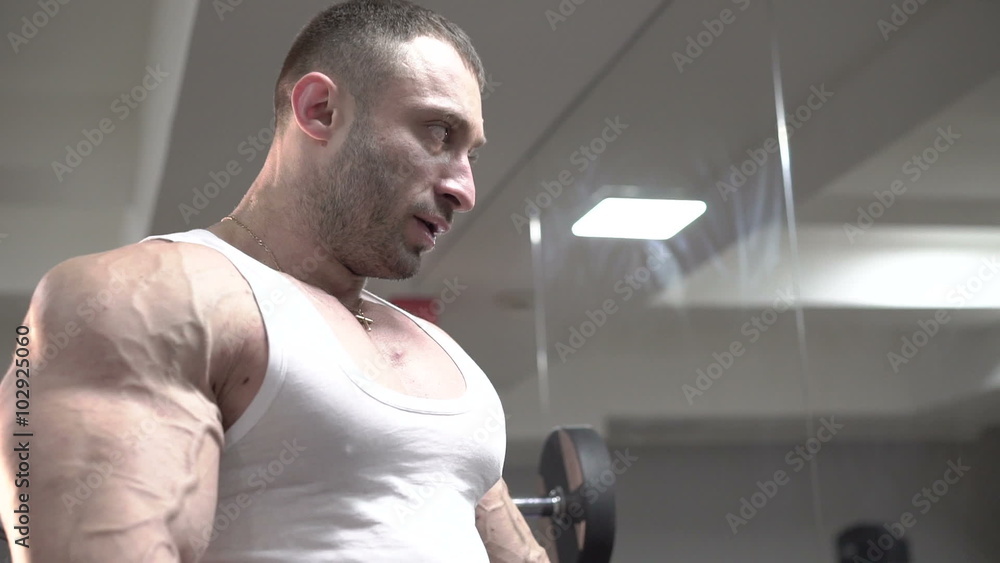 The champion of bodybuilding posing on camera with big biceps. Slowly ...