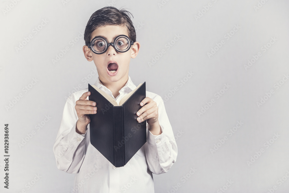 Funny nerdy little boy reacts while reading a book Stock Photo | Adobe ...