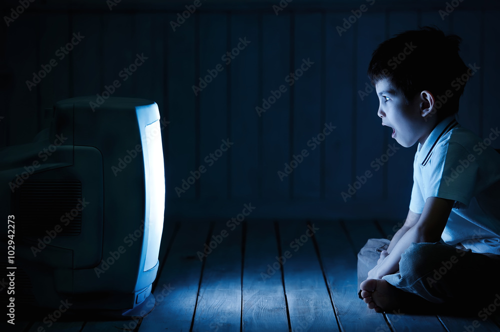 Boy watching TV at night Stock Photo | Adobe Stock
