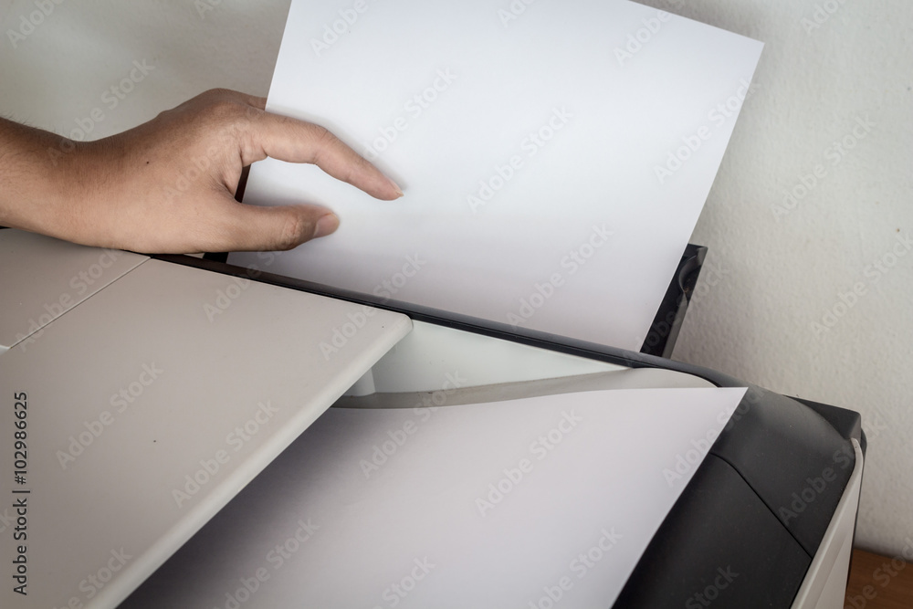 Hand holding paper sheets into printer tray Stock Photo | Adobe Stock