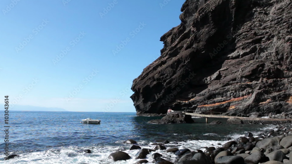 Giant cliffs of the Teno massif. Stony beach with pier on the Masca ...