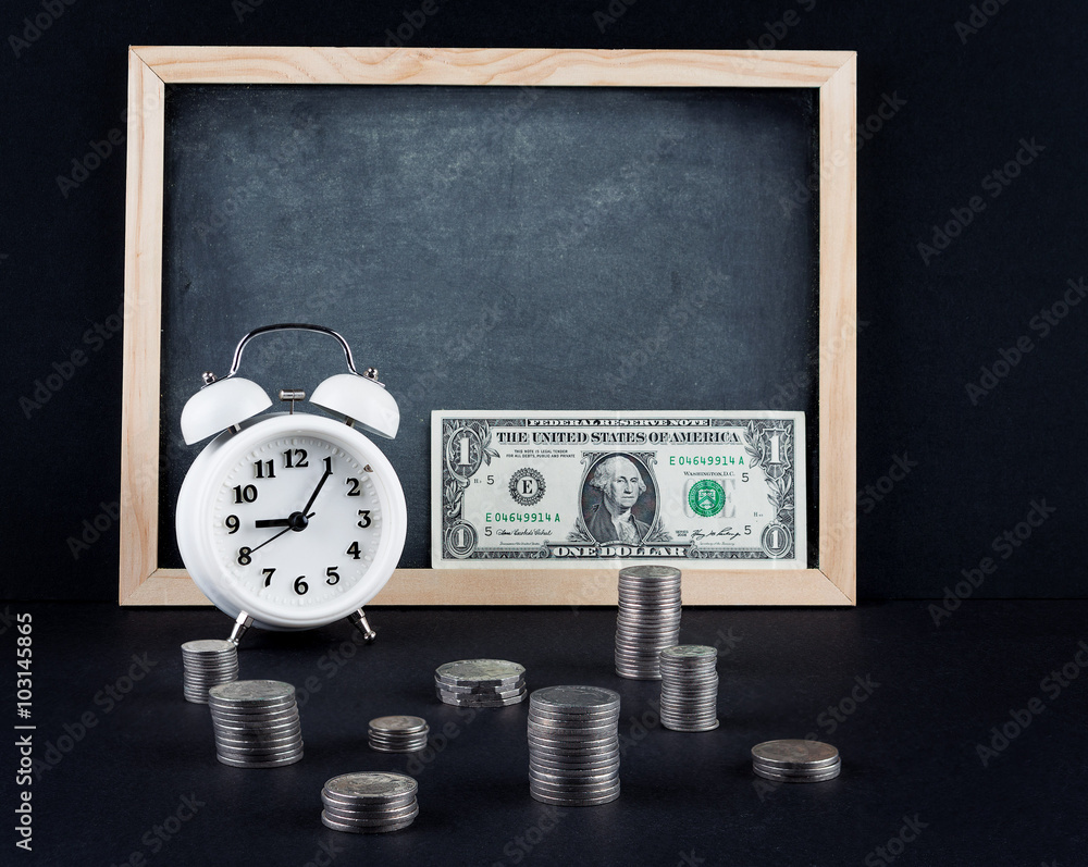 Vintage alarm clock showing 9 o'clock, coin towers and one dollar bill ...