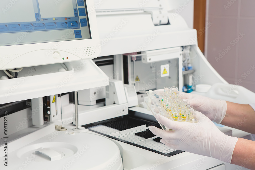 Lab tech loading samples into a chemistry analyzer Stock Photo | Adobe ...