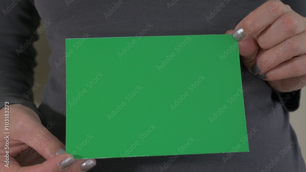 Green paper screen in woman hands for chroma key effects while camera ...