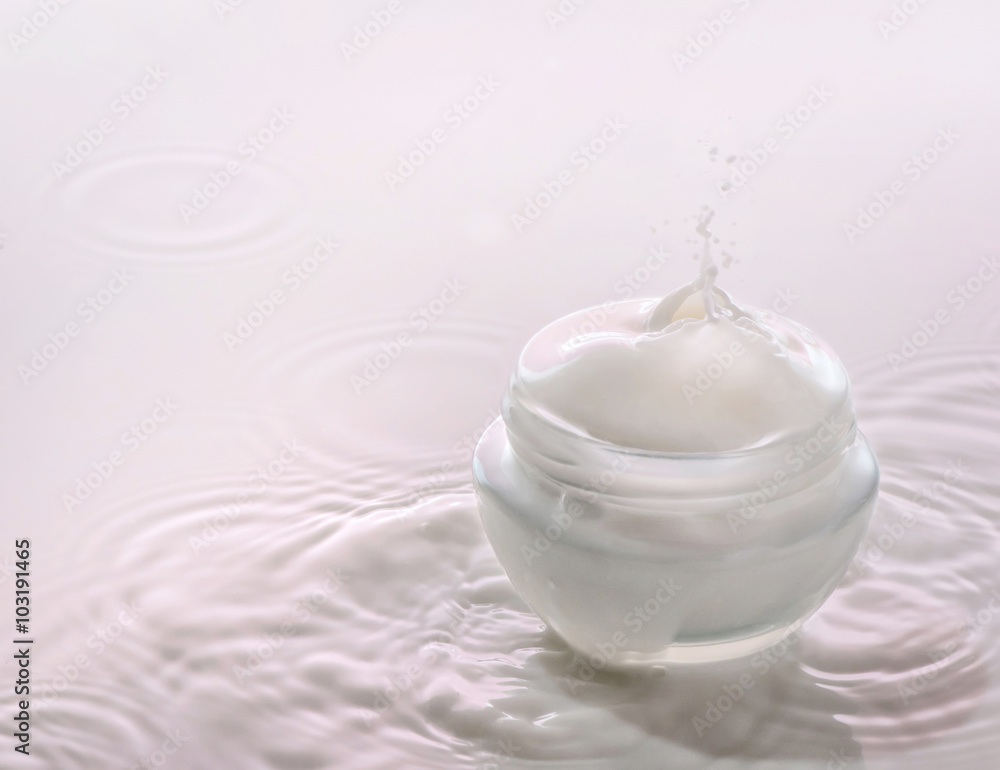 Moisturizing cosmetic cream stands on the pink milk background with ...