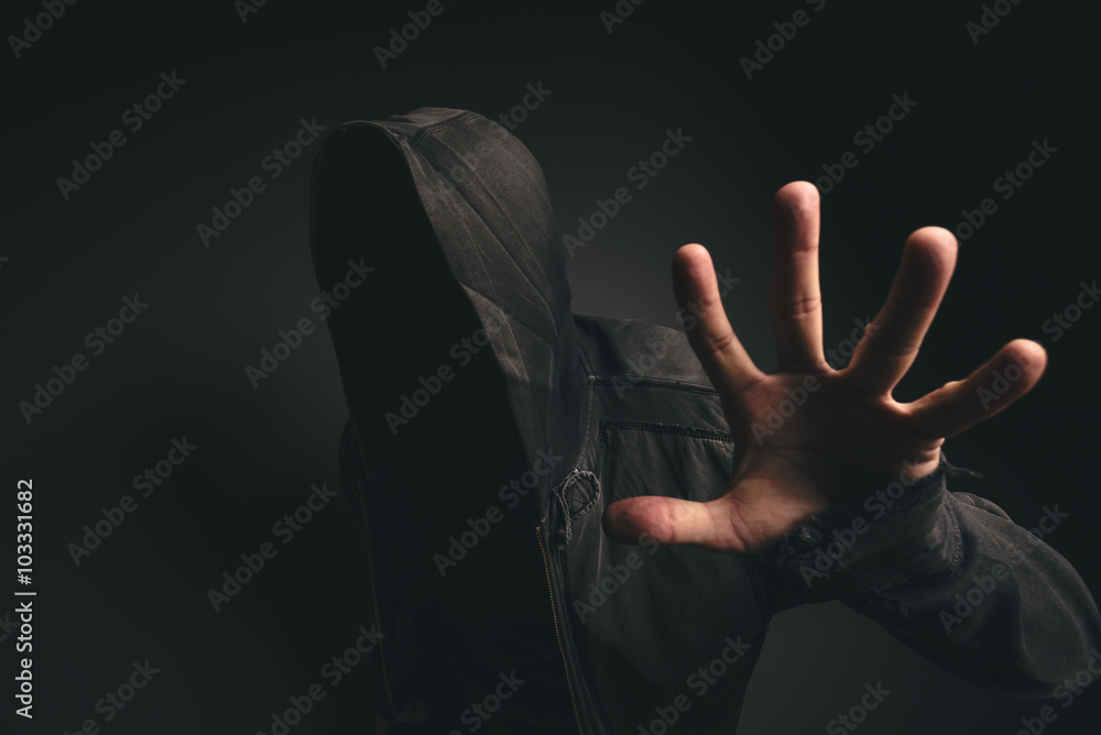 Spooky hooded person without face in dark room Stock Photo | Adobe Stock