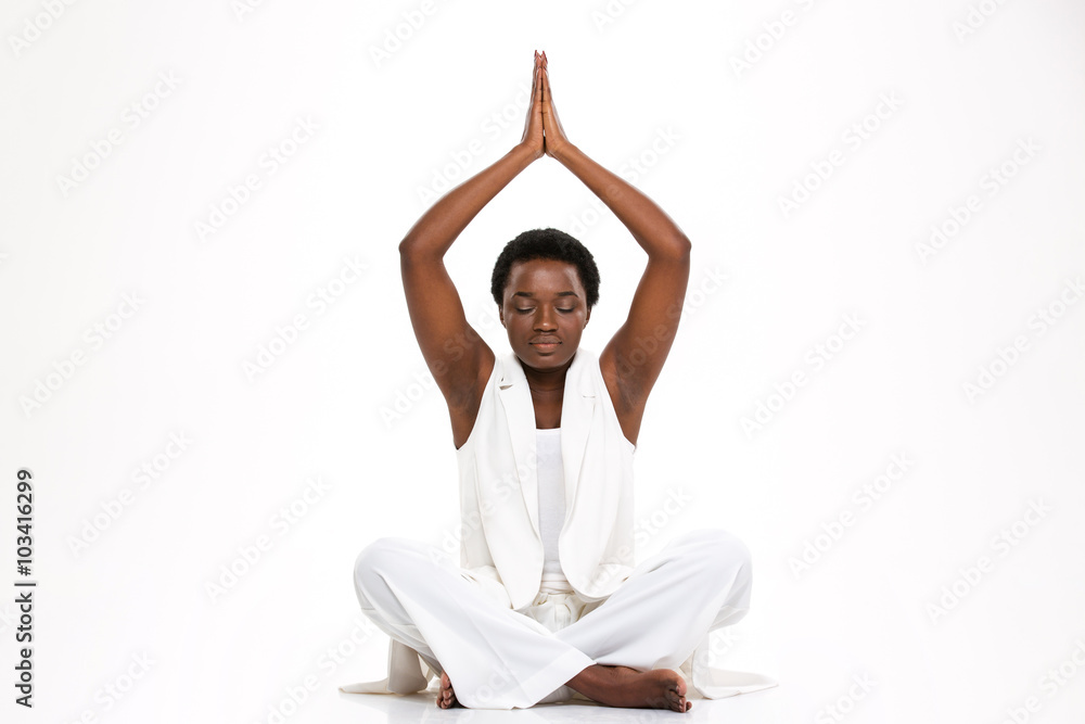 Attractive calm african american sitting in yoga pose and meditating ...