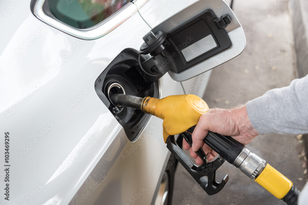 Hand holding fuel pump nozzle and refilling car Stock Photo | Adobe Stock