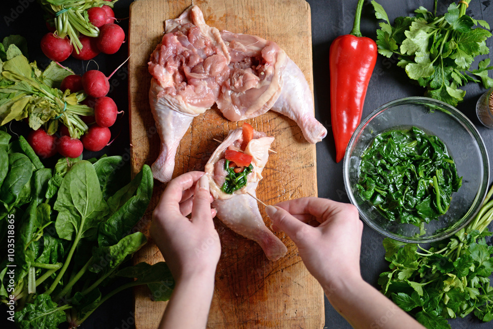Young woman preparing chicken with vegetables Stock Photo | Adobe Stock