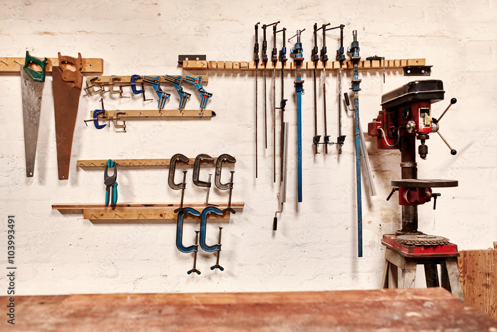 Workshop wall with tools in rows alongside a drill press Stock Photo ...