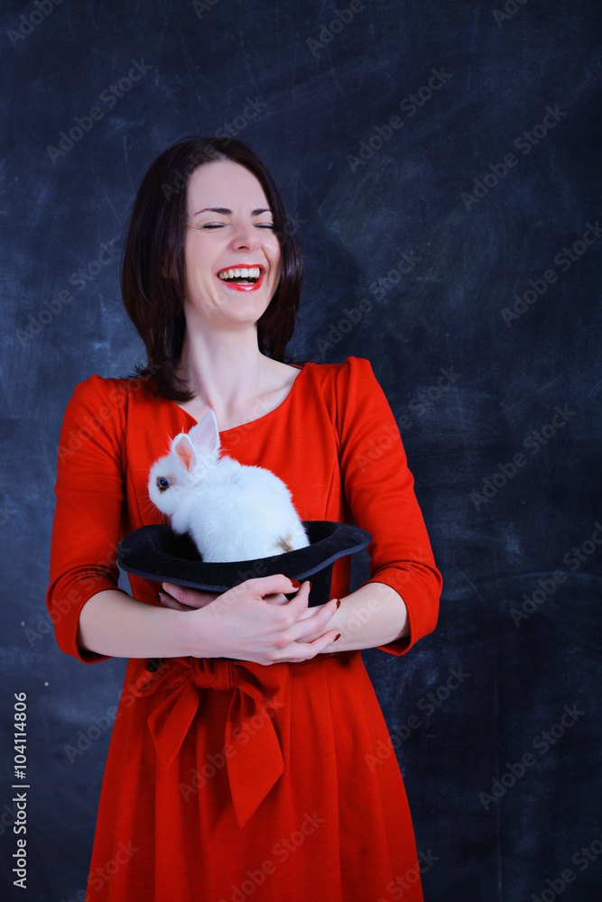Teacher of of Magic. Young beautiful girl in a red dress holds a black ...