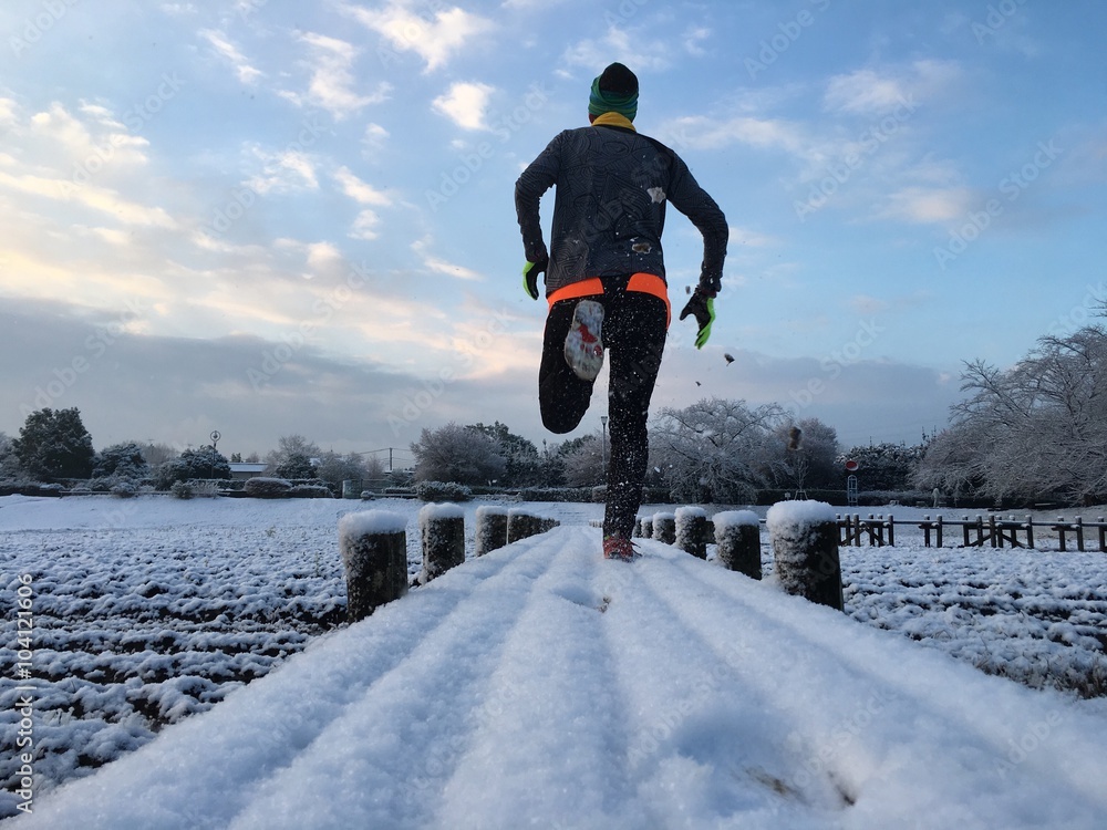 Man running on fresh snow covered early morning trail Stock Photo ...