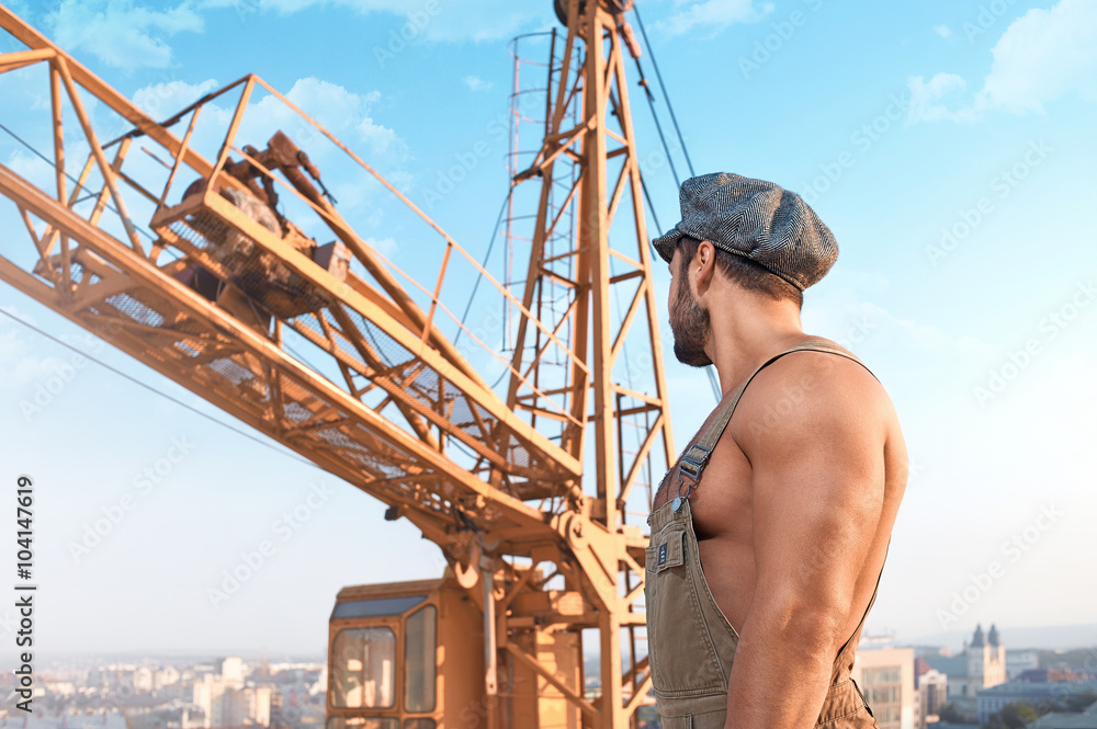 Human strength. Low angle shot of a strong muscular builder looking at ...