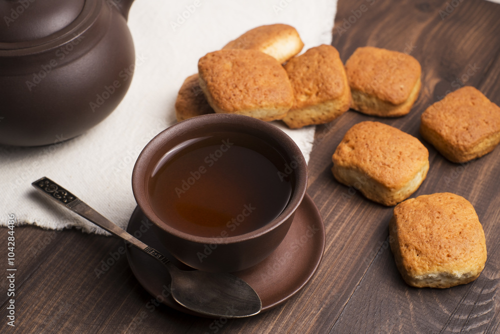 Square mug of tea with shortbread biscuits, on a brown table and a ...