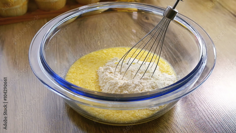 Closeup of mixing flour with already beaten up eggs and sugar using an ...