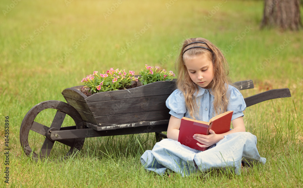 Adolescent girl reading a book in the garden Stock Photo | Adobe Stock