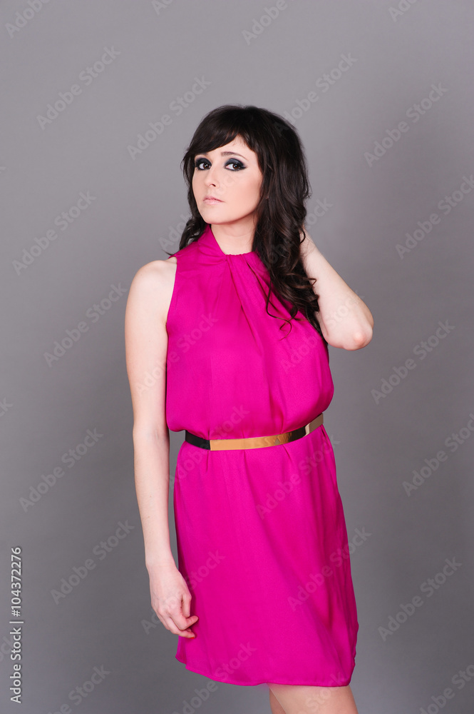 Beautiful girl 20-24 year old posing in studio over gray. Wearing pink ...