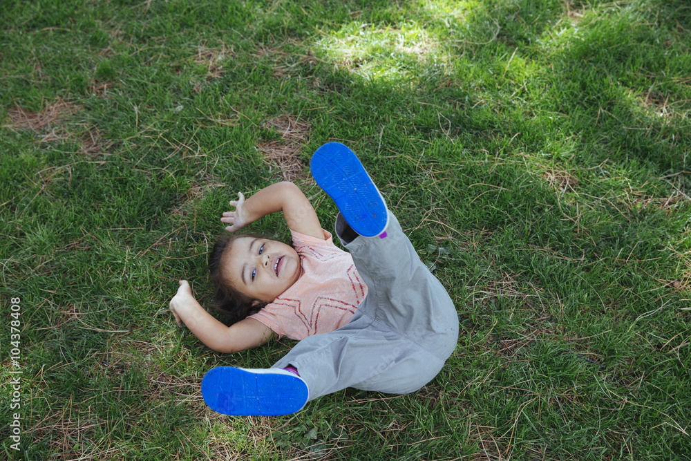 Little girl lying on lawn with legs up Stock Photo | Adobe Stock