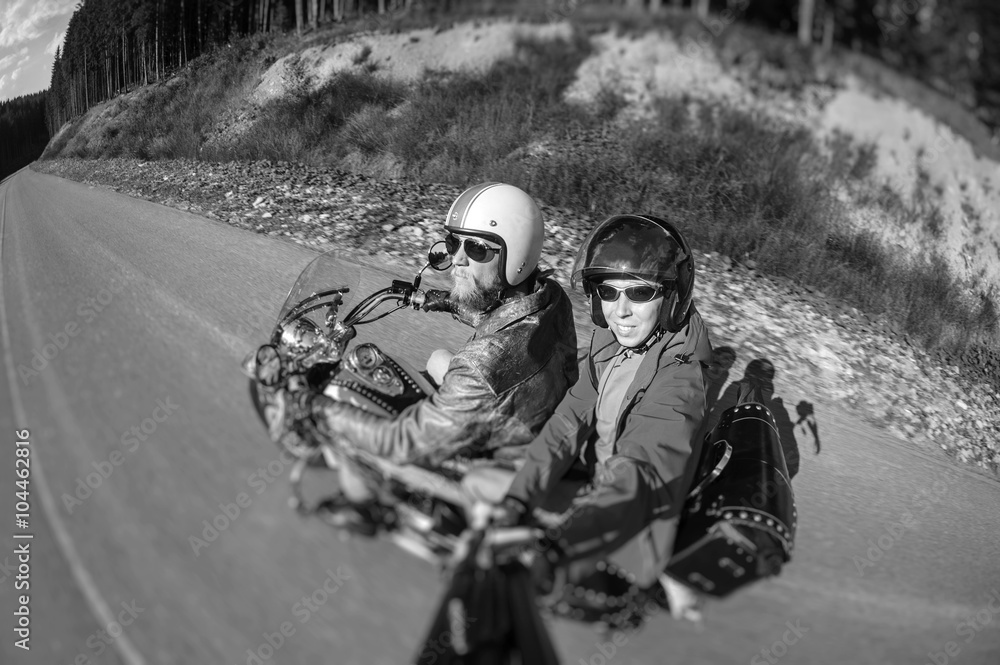Biker riding his motorcycle on the road with the passenger looking to ...