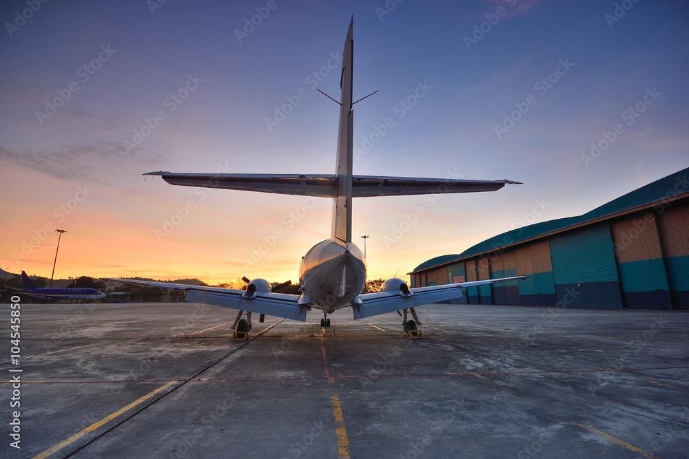 Small aeroplane infront of aircraft hangar during sunrise Stock Photo ...