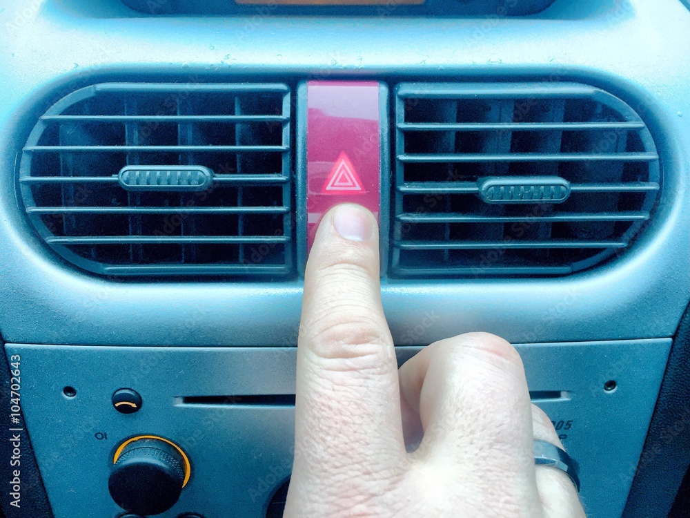 pushing the emergency blinkers button in a car Stock Photo | Adobe Stock