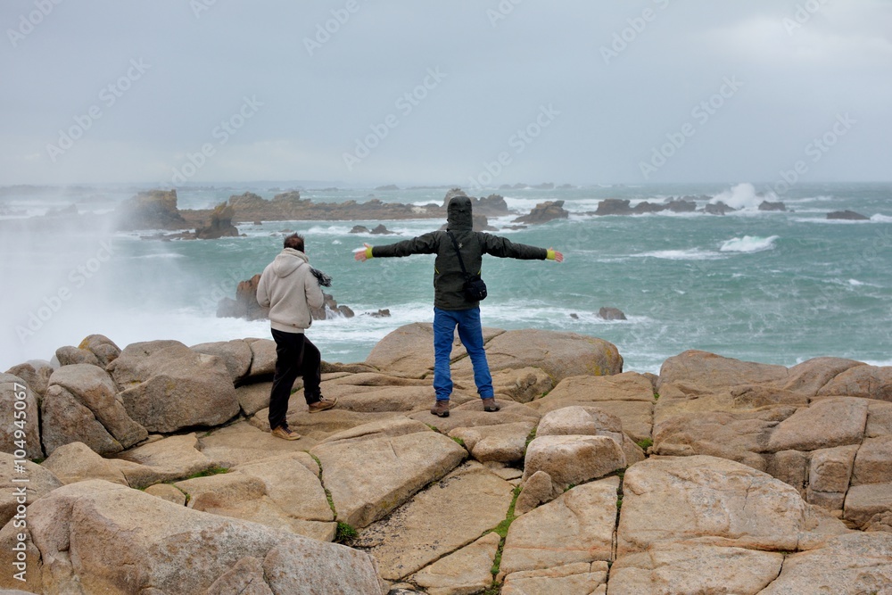 Foto de Deux jeunes face au vent et la mer pendant une tempête à ...