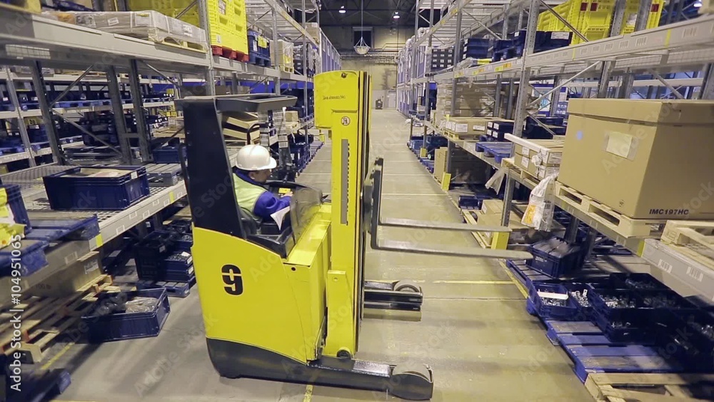 Adult worker on autoloader taking box from metal rack. Stock Video ...