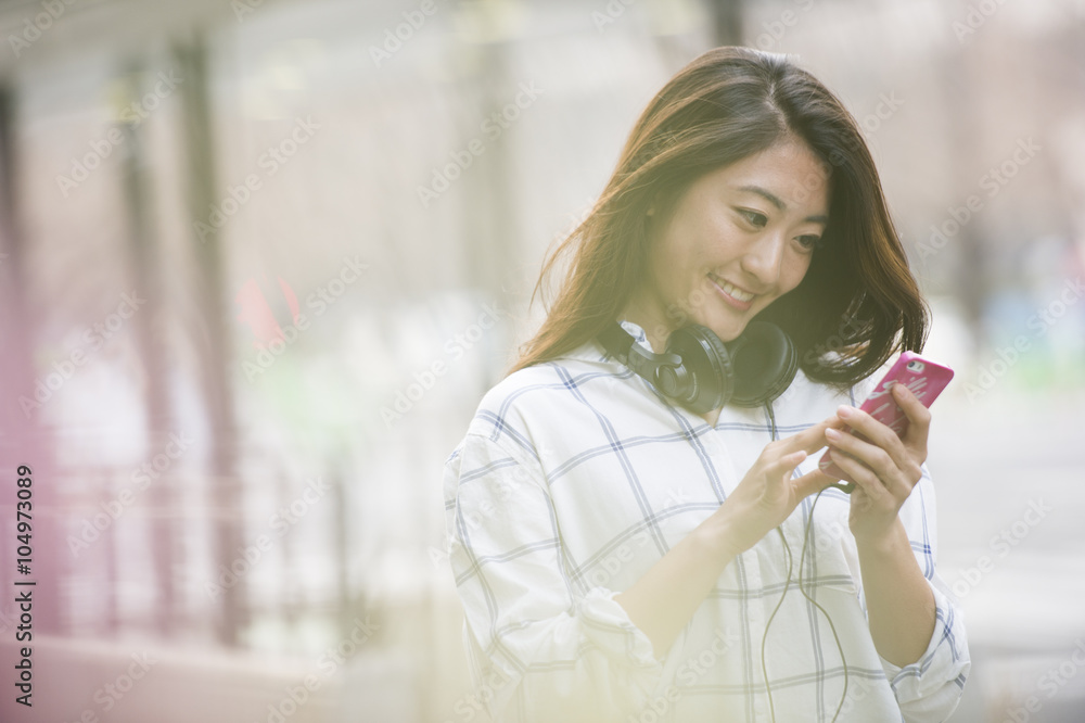 Walking while watching the smartphone to young women holiday Stock ...