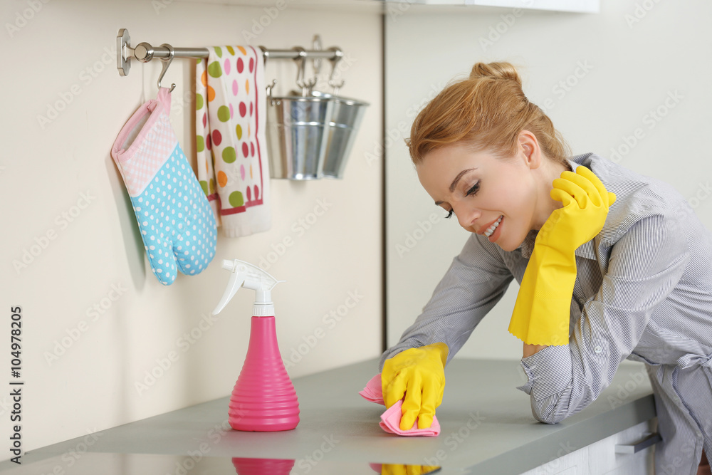 Young woman scrubbing the kitchen counter with a rag Stock Photo ...