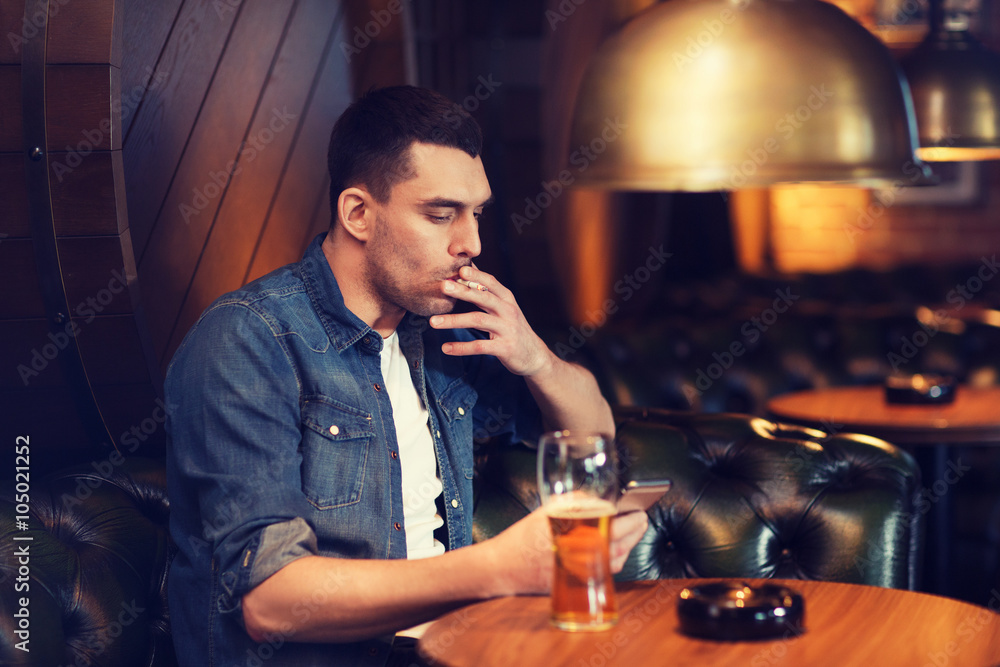 man drinking beer and smoking cigarette at bar Stock Photo | Adobe Stock