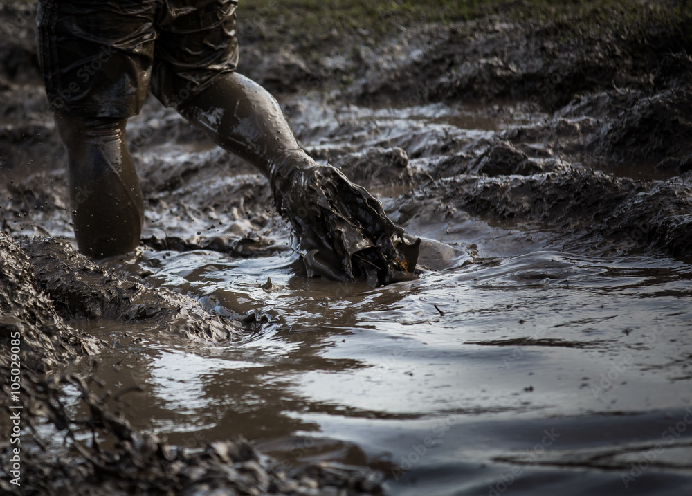 Deep muddy water with feet splashing through and dragging the mud in a ...