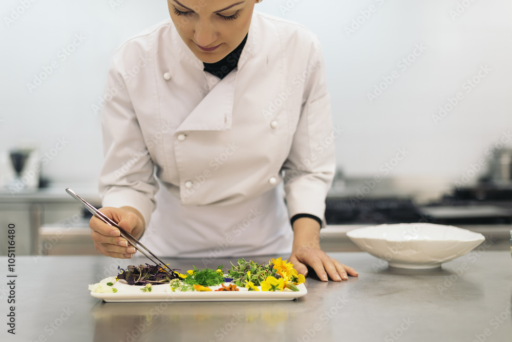 Pretty professional chef cooking. foto de Stock | Adobe Stock