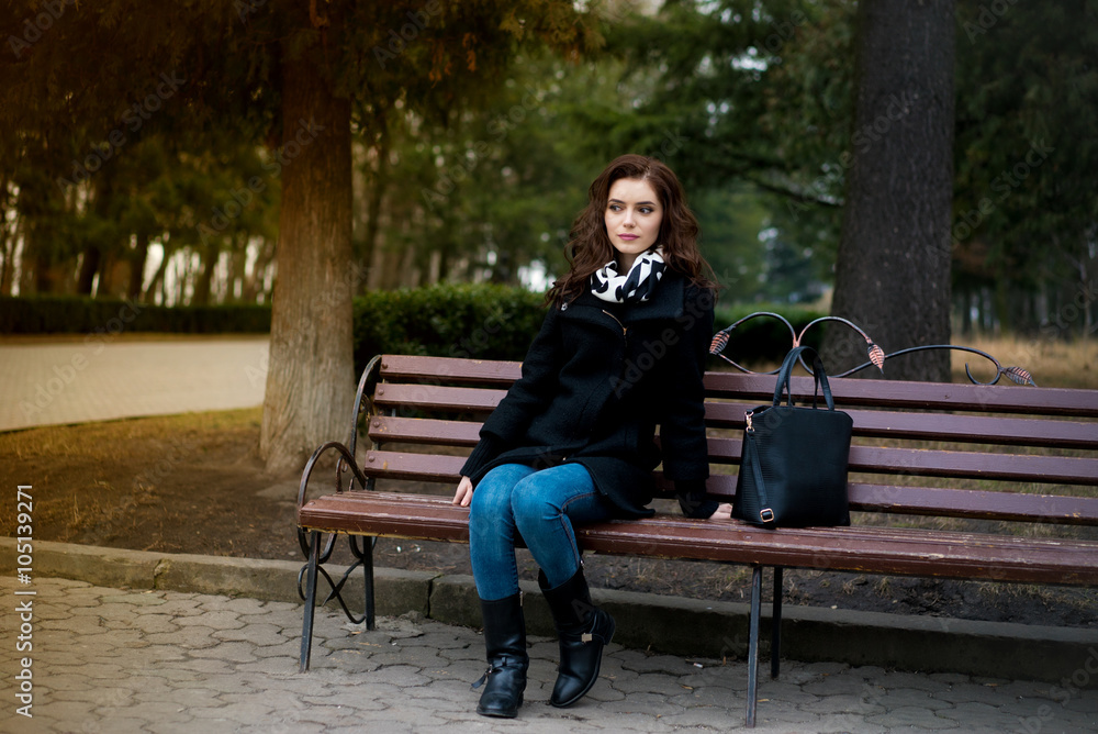 Beautiful girl sitting on a park bench Stock Photo | Adobe Stock