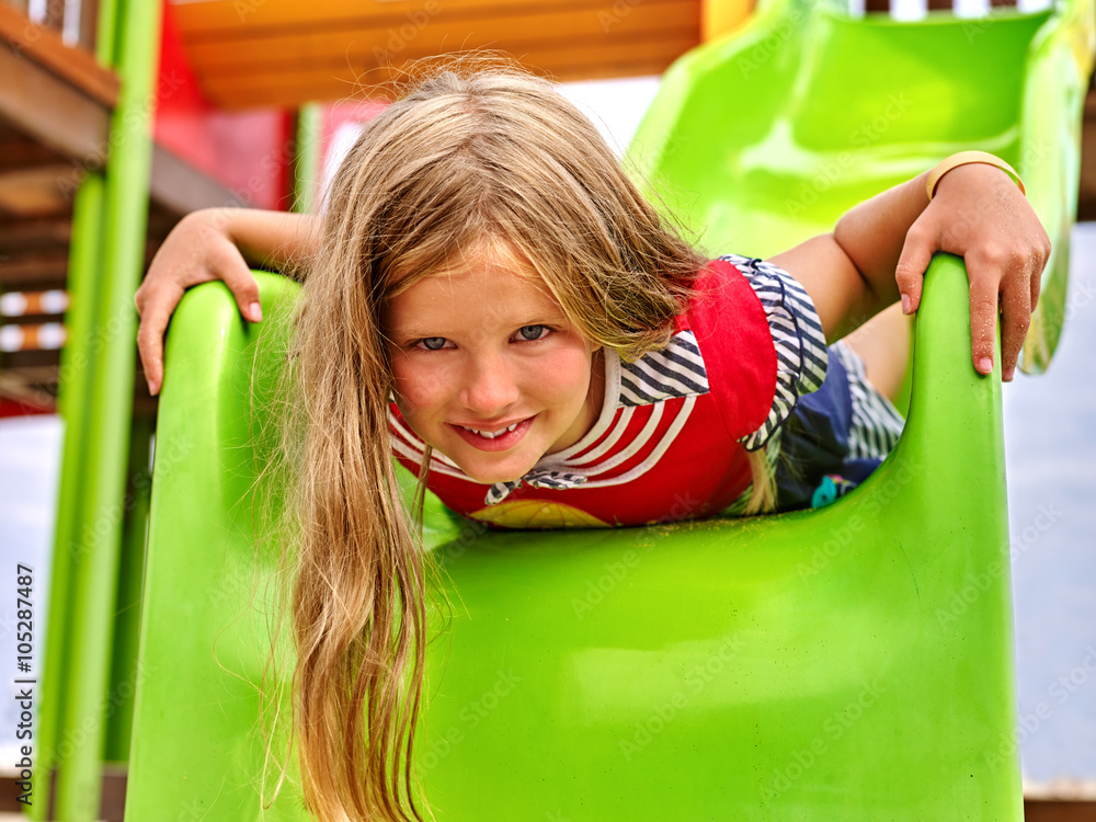 Child girl upside down on park playground game. Girl slides on children ...
